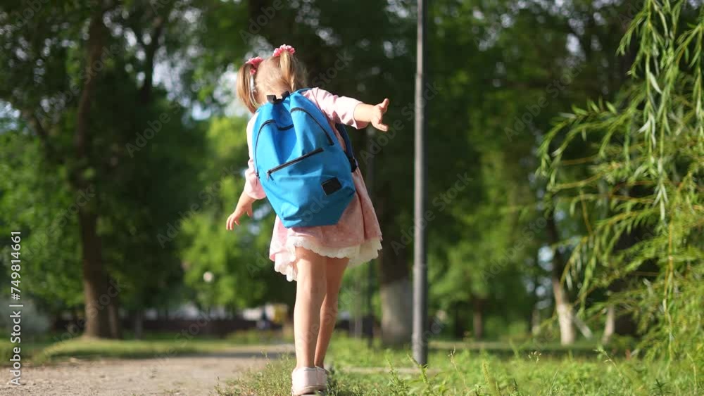 schoolgirl goes to school through the park along the path. kid dream ...