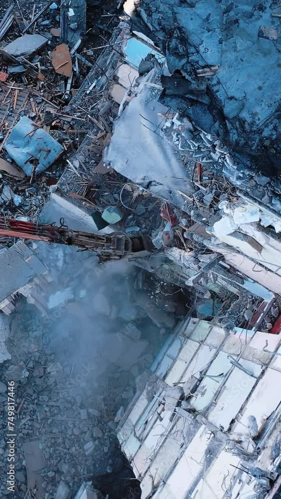 Long claw of an excavator destroys the concrete parts of the building ...