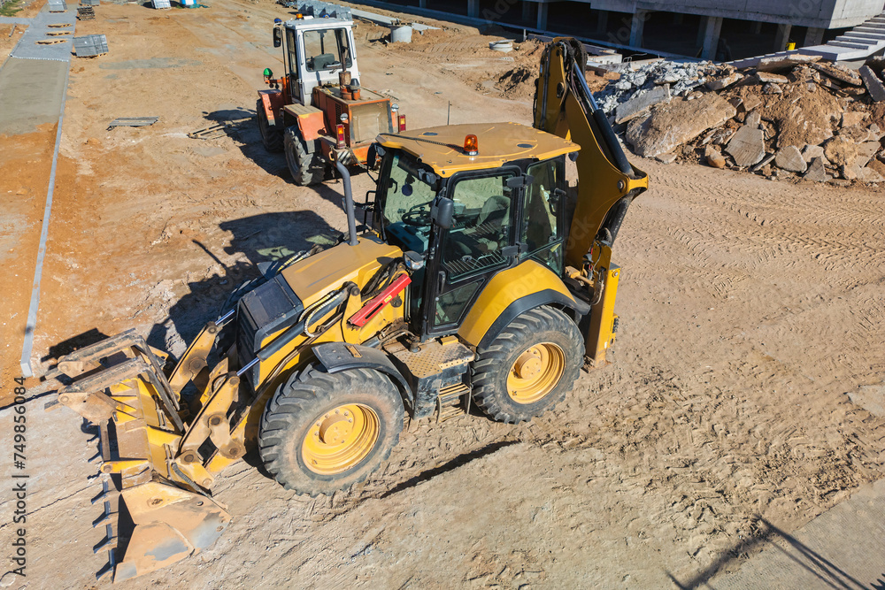 Universal excavator or loader with folded bucket at construction site ...