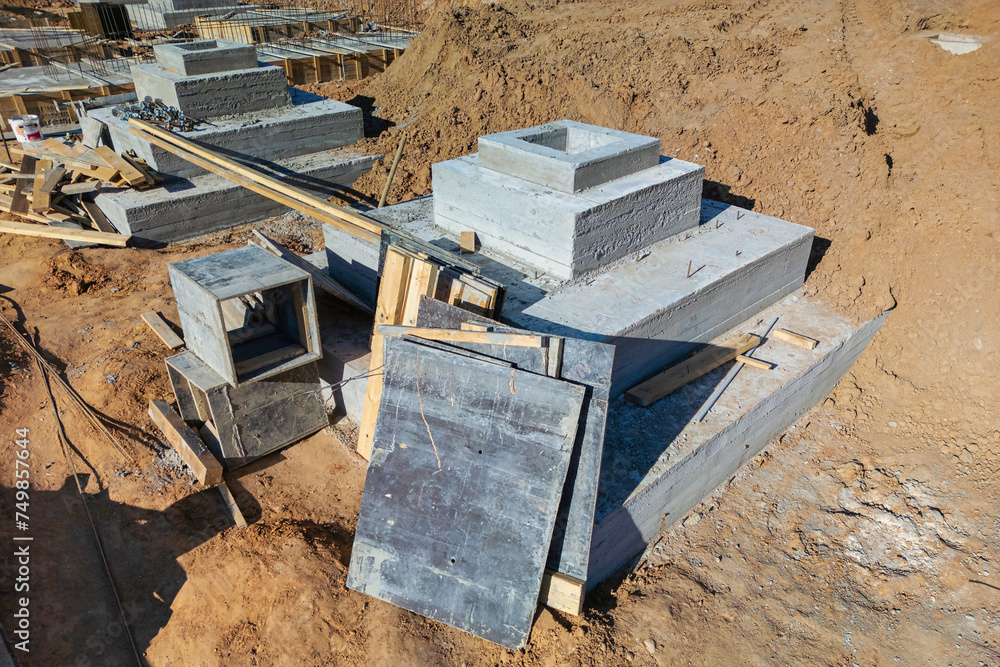 A cluster of concrete blocks rests on a barren dirt field, ready for ...