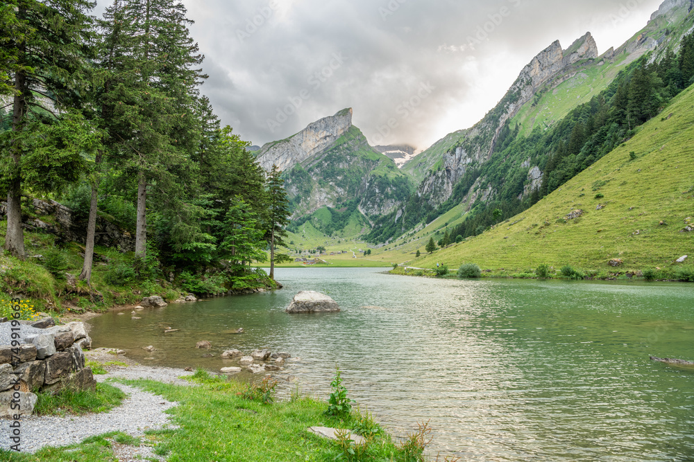Beautiful summer view on lake Seealpsee in the Swiss alps.. Cloudy sky ...