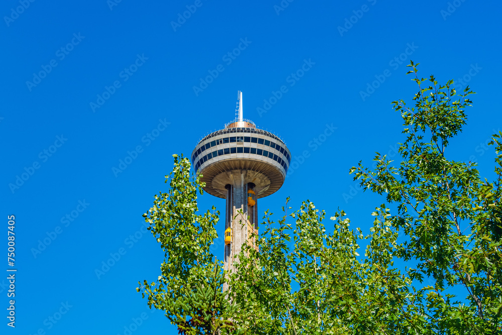 Observation Tower rises majestically above the treetops against a clear blue sky in Niagara ...