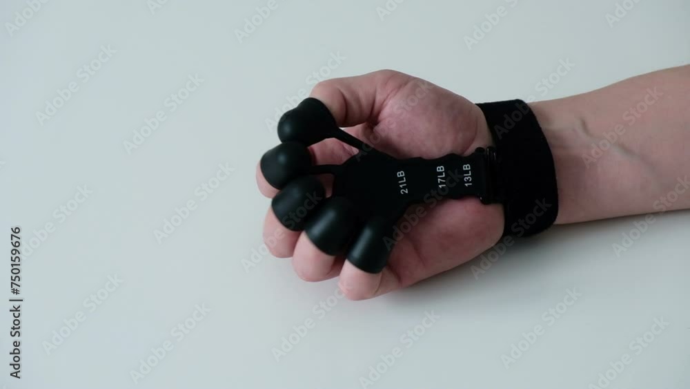 Physical therapy for the arm using an rubber expander, a male hand ...