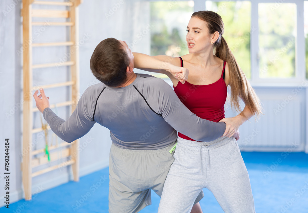 Self-defense training - woman practicing blows to the head of a male ...