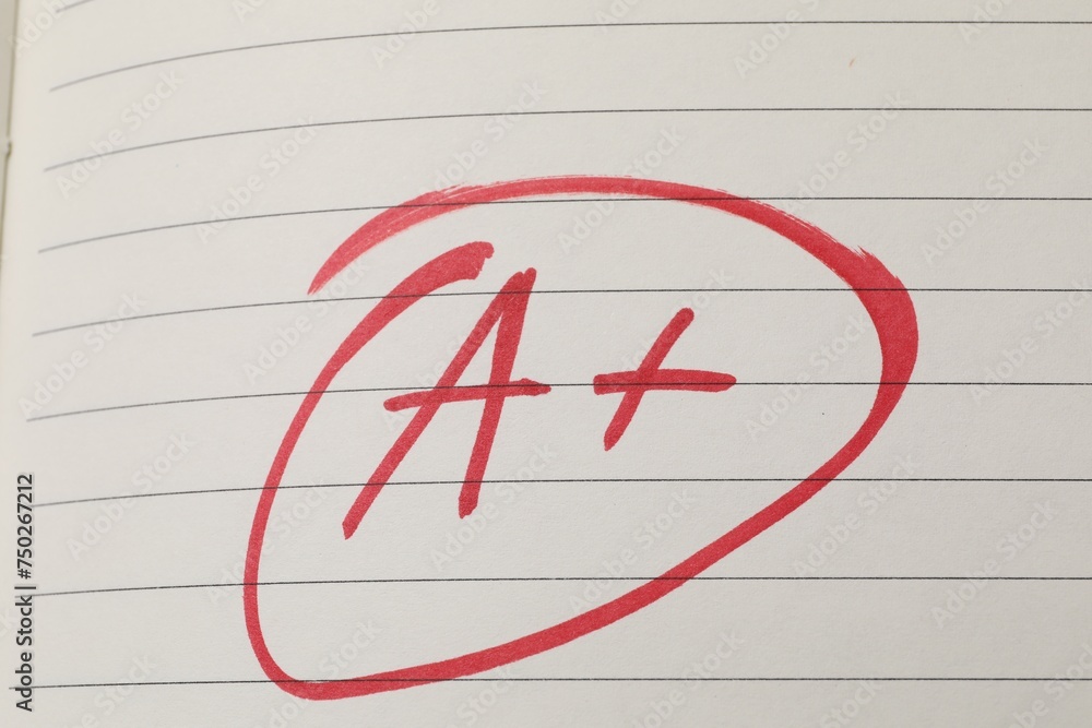 School grade. Red letter A with plus symbol on notebook paper, top view ...