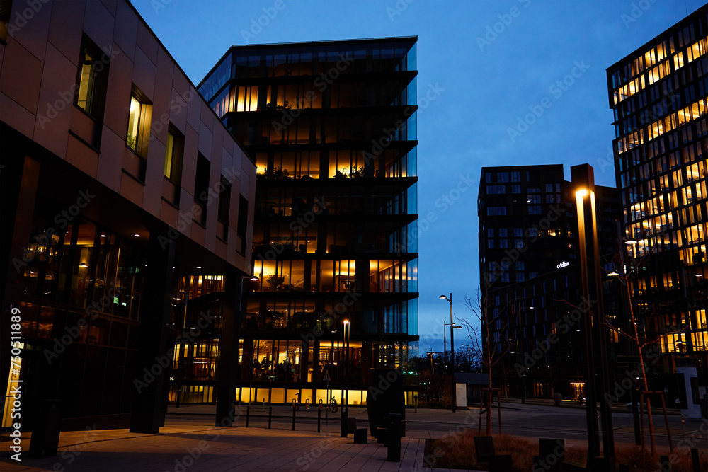 Office building lights up the evening with windows glowing in the dusk ...