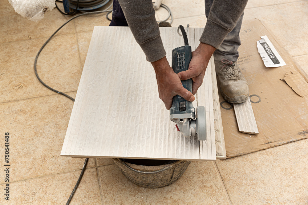 Albañil trabajando con la radial para cortar una baldosa. Stock Photo ...