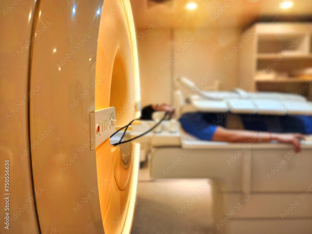 A patient lies down comfortably on the MRI scanner, undergoing a ...