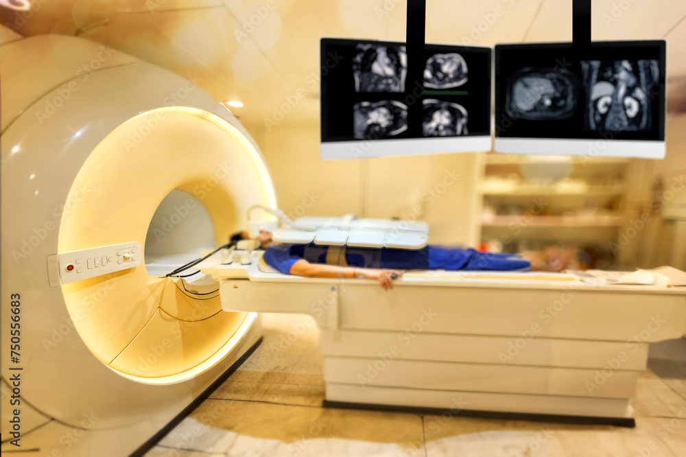 A patient lies down comfortably on the MRI scanner, undergoing a ...