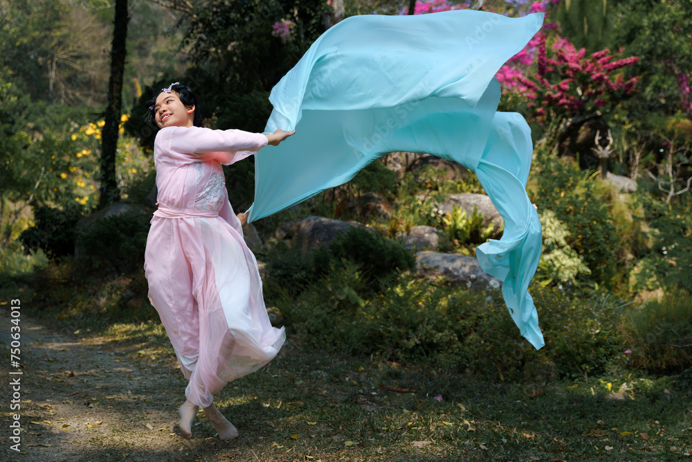 Pretty Asian girl in a beautiful traditional dress happy dancing with a ...