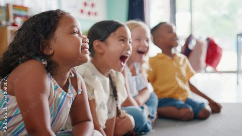 Line of laughing primary or elementary school students sitting on floor ...