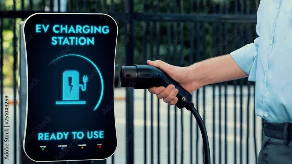 Businessman pull out EV charger from charging station to recharge ...