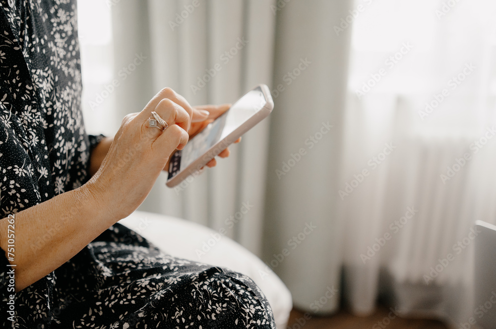 Crop female tapping phone screen in bedroom Stock Photo | Adobe Stock