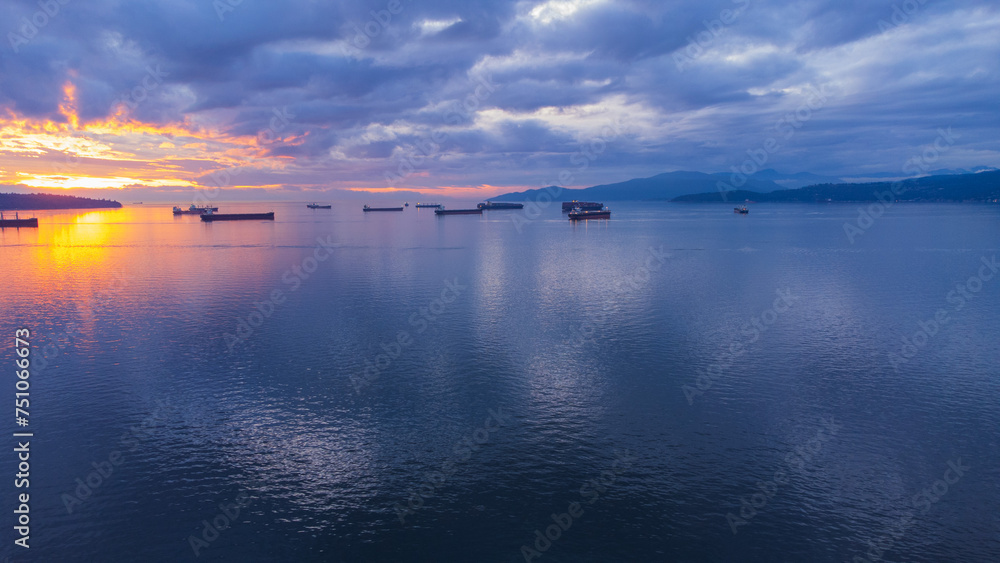 Sun setting over UBC peninsula. Orange yellow light reflects on the ...