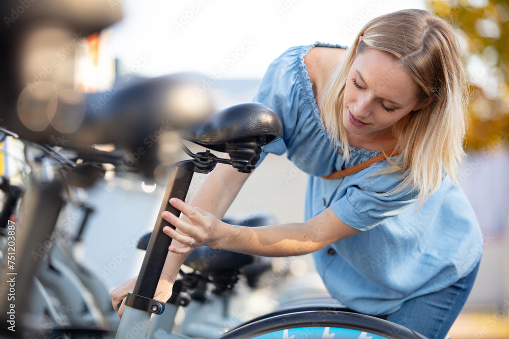female cyclist adjusting seat on a bicycle Stock Photo | Adobe Stock