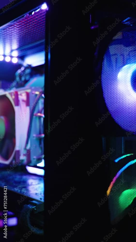 Vertical video. Dark room with a gaming computer with a transparent ...