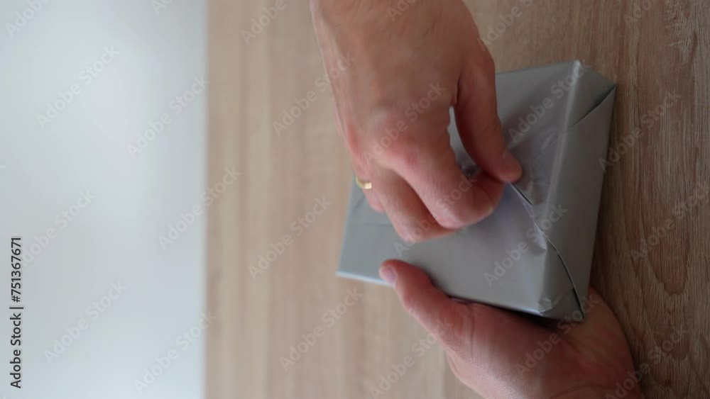 Man spinning and unwrapping a gift box with question mark on wooden ...