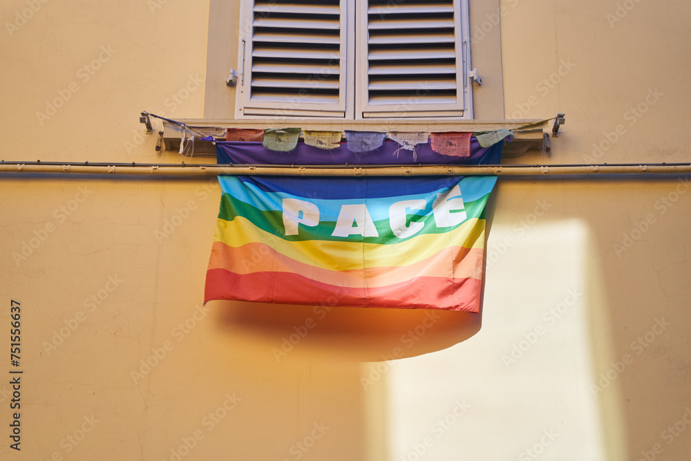 A rainbow flag with the word peace painted in blue, displayed as a ...