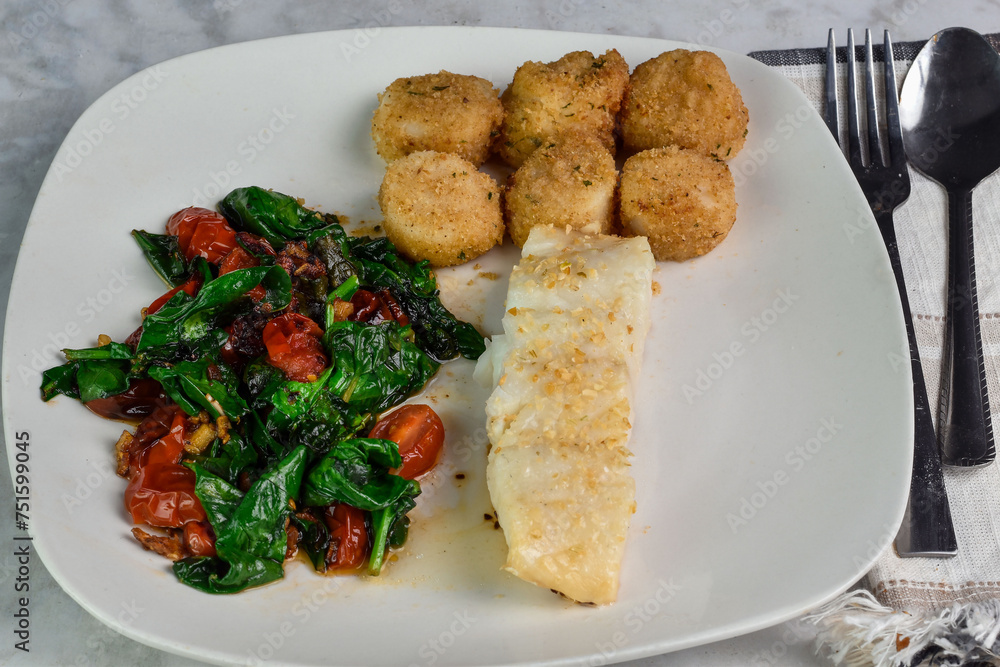 seasoned baked cod with sauteed spinach and tomatoes Stock Photo ...