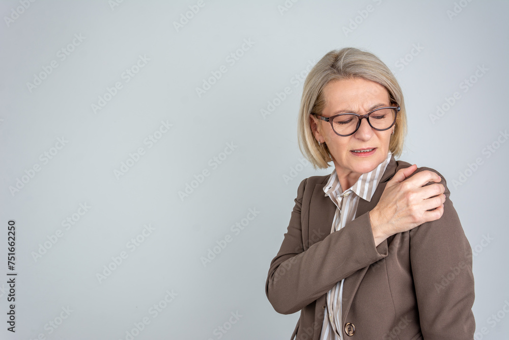 Senior woman with shoulder pain. Elderly business woman is enduring ...