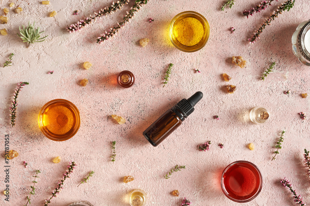 Pink background with bottles of aromatherapy essential oil with ...