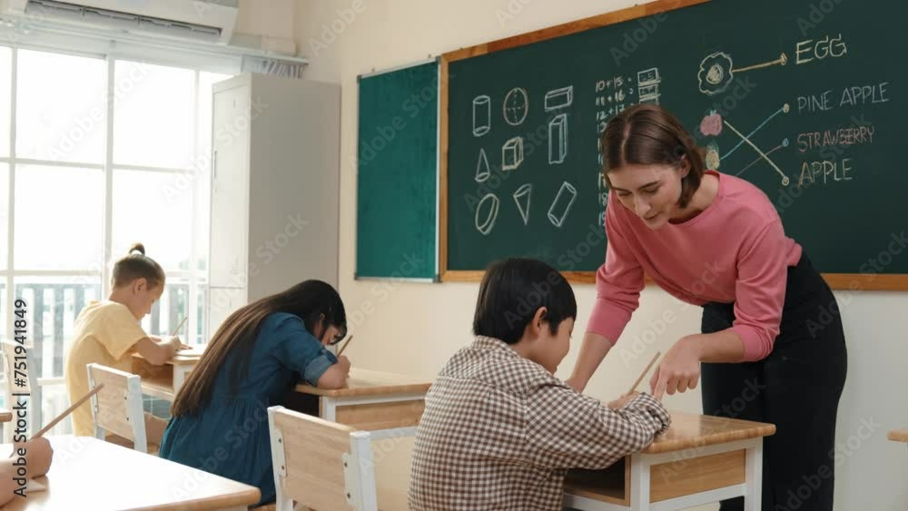 Smart teacher checking cute student homework while explaining idea at ...