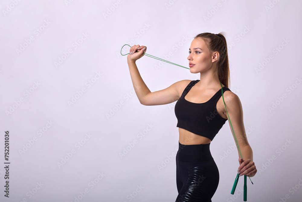 Young beautiful girl is a fitness trainer performing an exercise with a ...