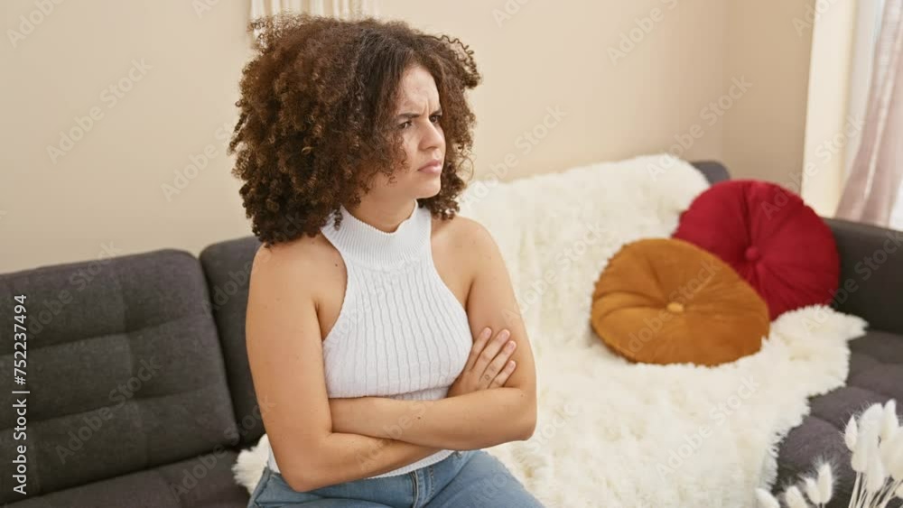 Nervous, doubting hispanic woman with curly hair, a skeptic frowning ...