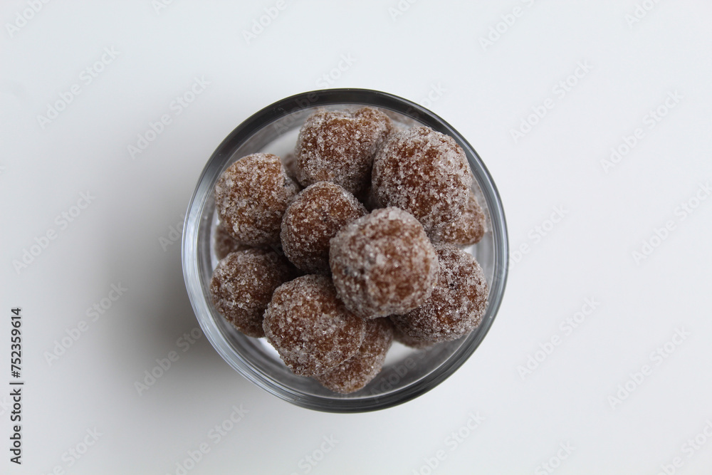 Tamarind ball candy in small glass. Sweet and sour candy made from ...