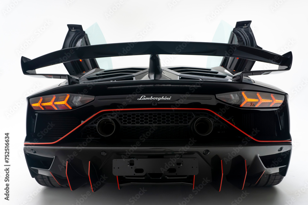 Rear end view of a matte black Lamborghini Aventador SVJ with scissor ...