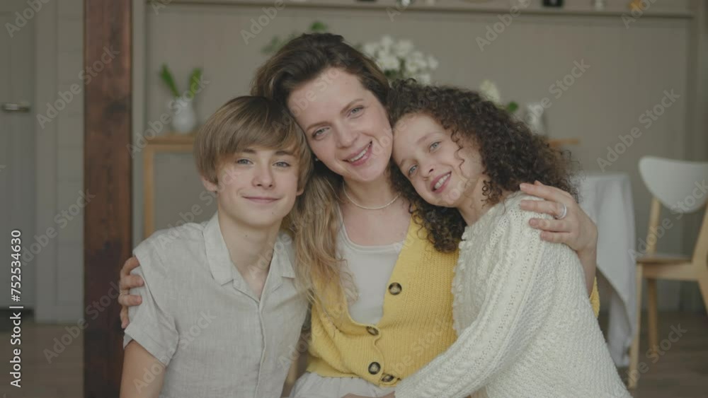 Happy sweet single mum hugging her kids girl and boy, daughter and son ...