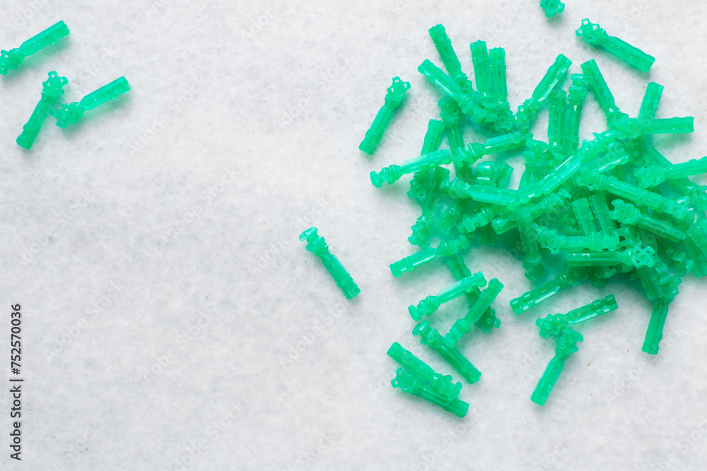 Blood lancets on a marble countertop, top view of green lancets on a ...