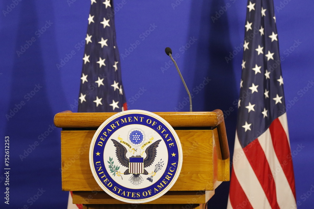 United States of America Department of State logo and flag on stage for ...