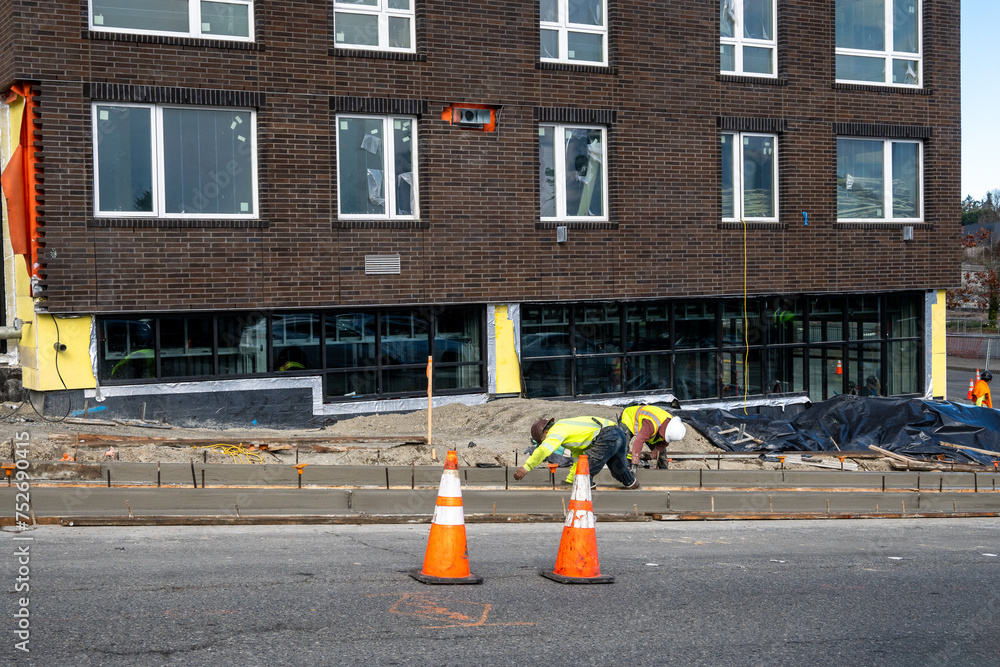 New brick building under construction with workers doing manual labor ...