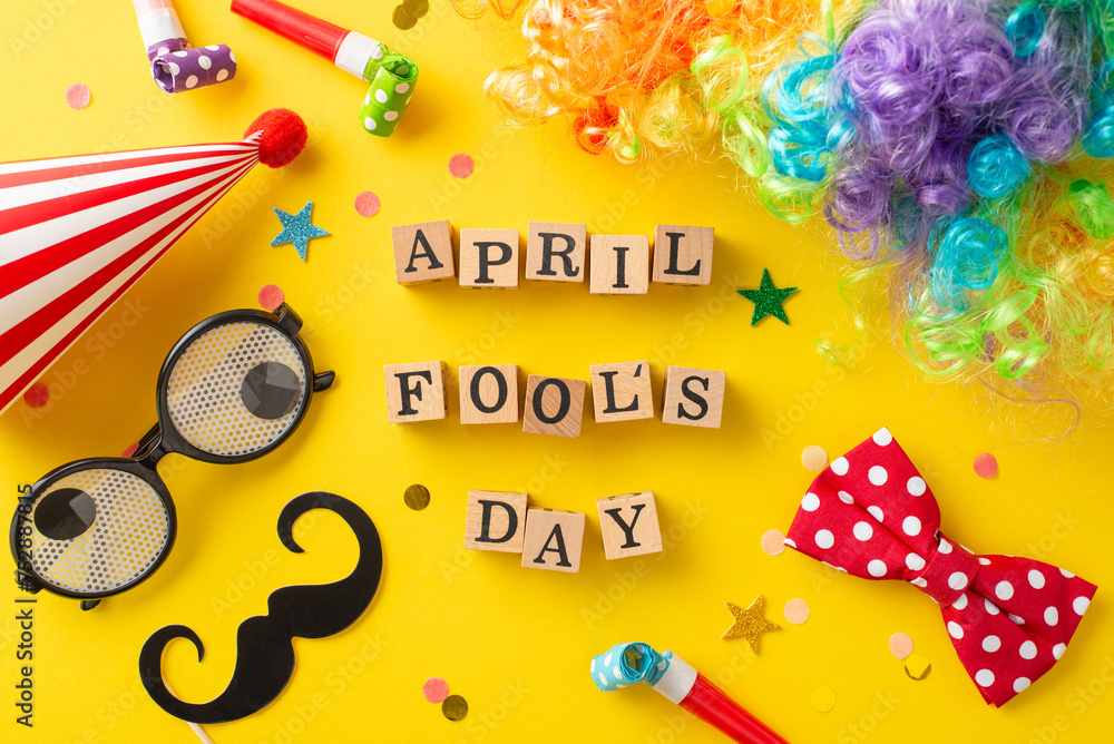 Top view snapshot of wooden letters forming "April Fool's Day," next to ...