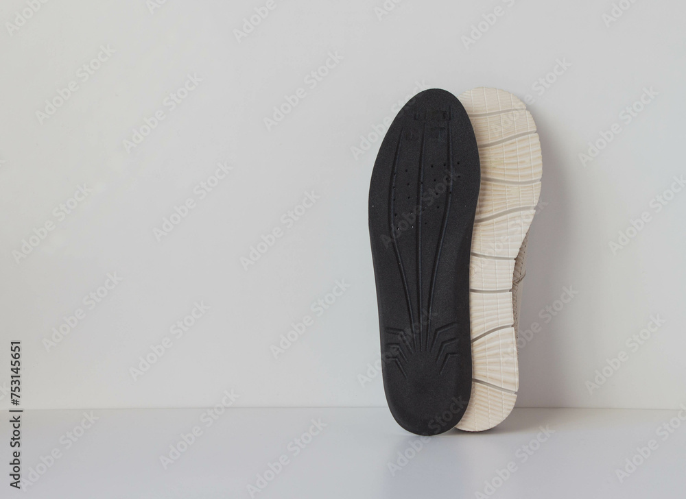The black insole and sole of the sports shoe are positioned vertically ...