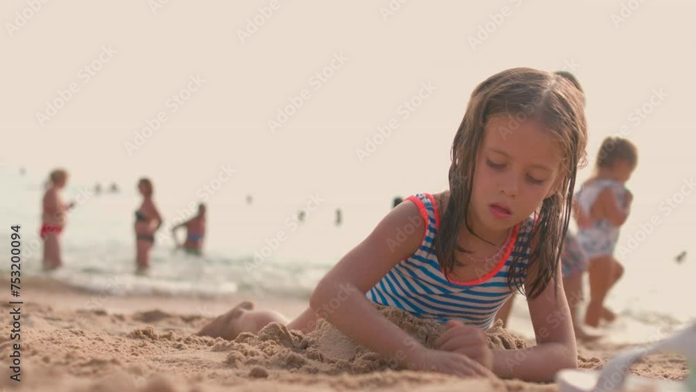 Little girl playing on beach on summer vacation Little girl builds sand ...