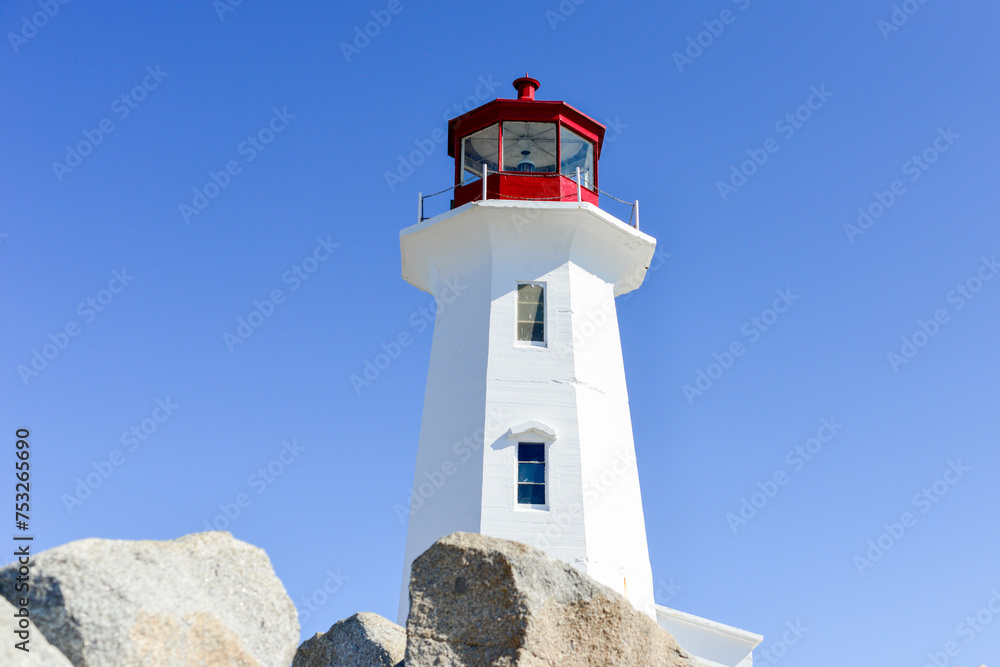 The lighthouse tower is made of white hexagonal, six-sided tapering ...