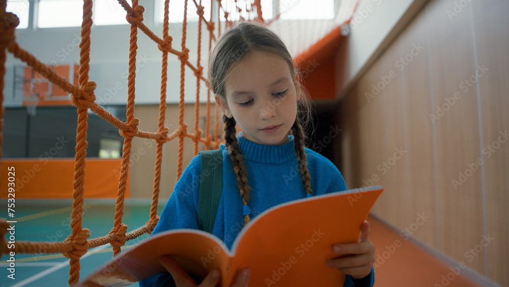 Little girl studying in gym school inside education self-study reading ...