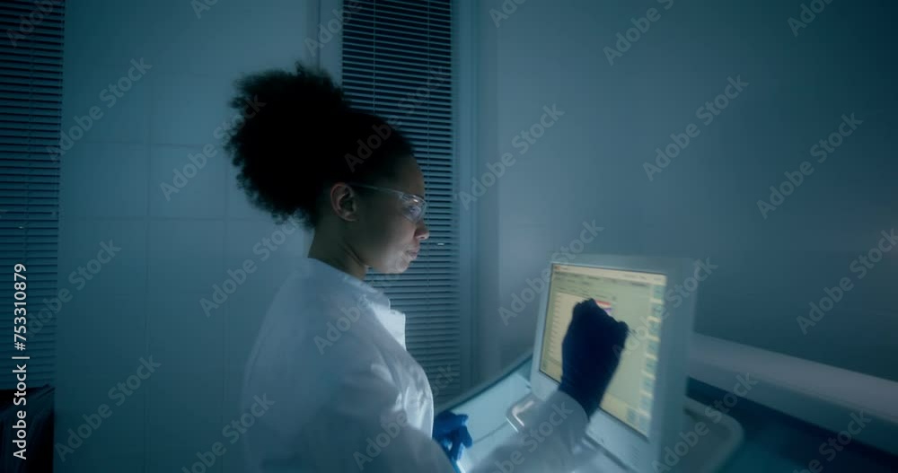 Work in a medical laboratory. A woman in a lab coat, disposable gloves ...
