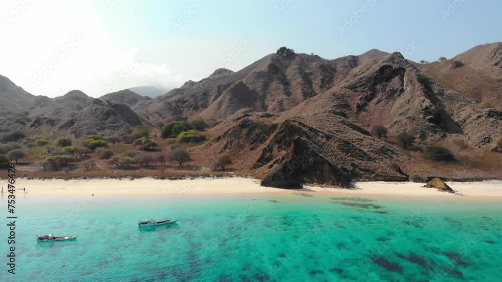 turquoise water and steep Rugged Hills Of Pantai Merah (The Pink Beach ...