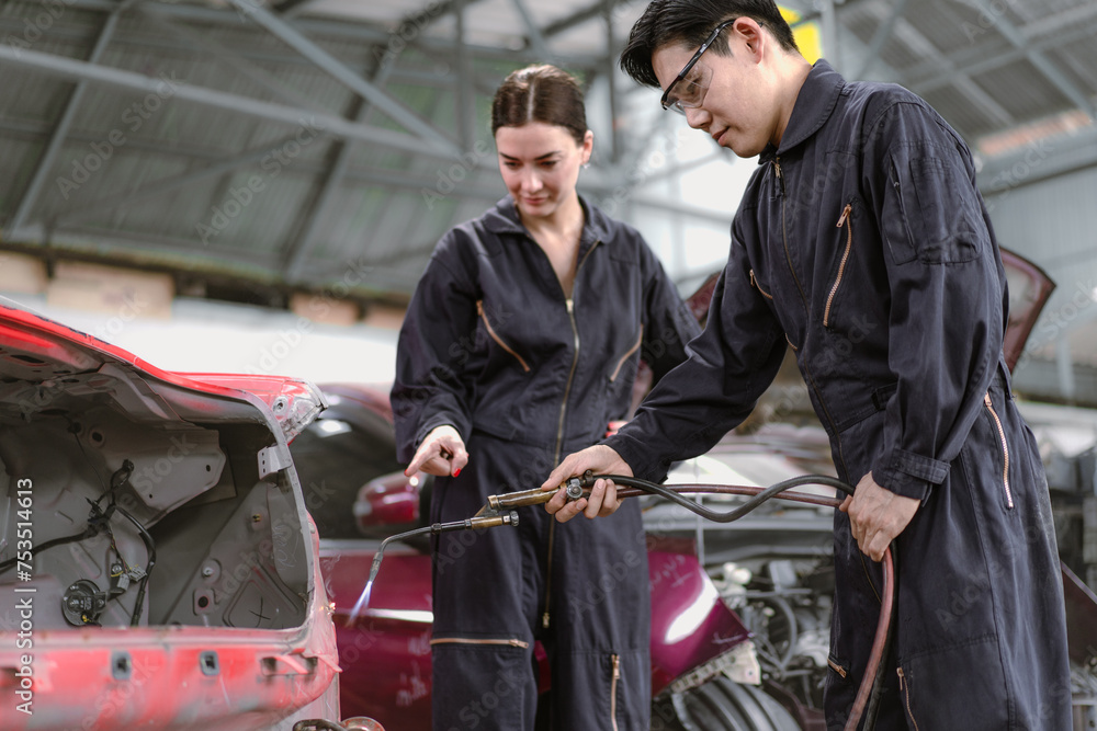 Skilled welder welding damage auto body car with blue spark at workshop ...