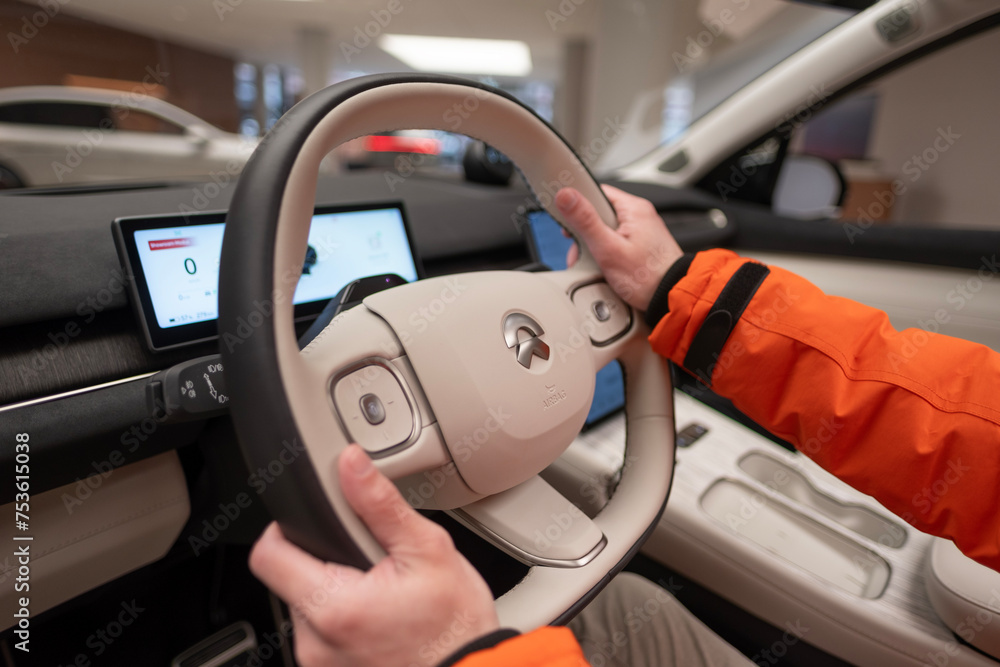 steering wheel NIO EL7, close-up male driver's hand manipulates on ...
