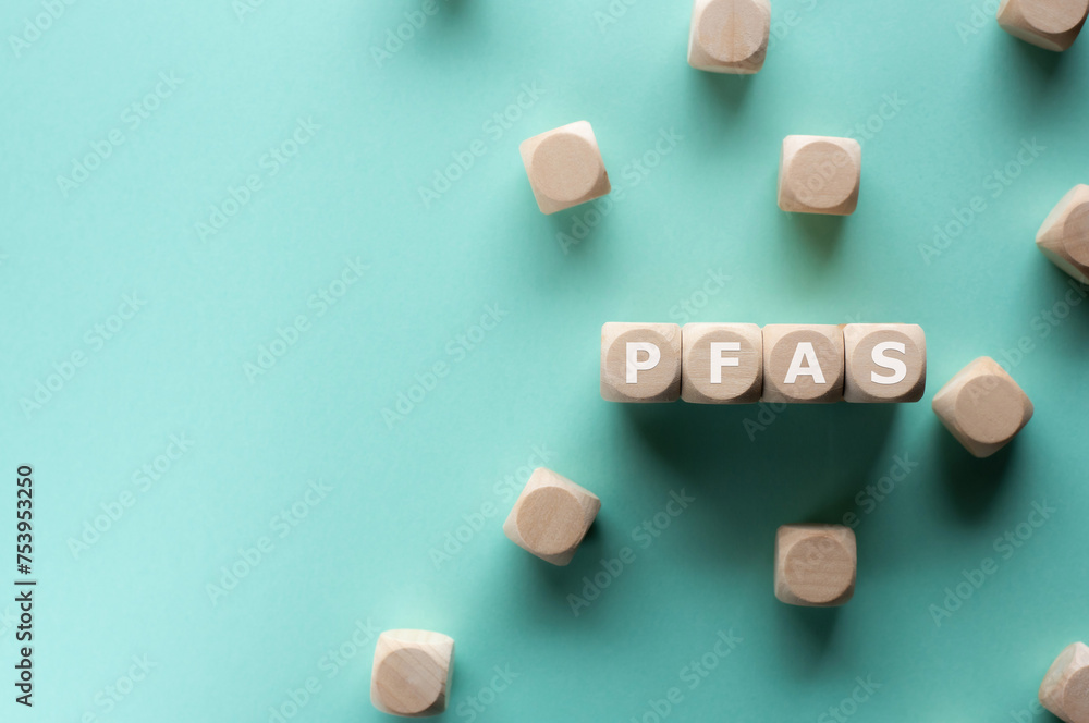 There is wood cube with the word PFAS. It is an abbreviation for Per ...