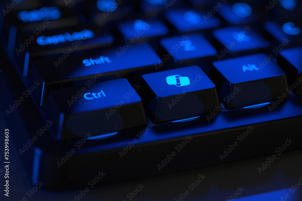 Copilot AI logo on a black computer keyboard with blue backlight, close ...
