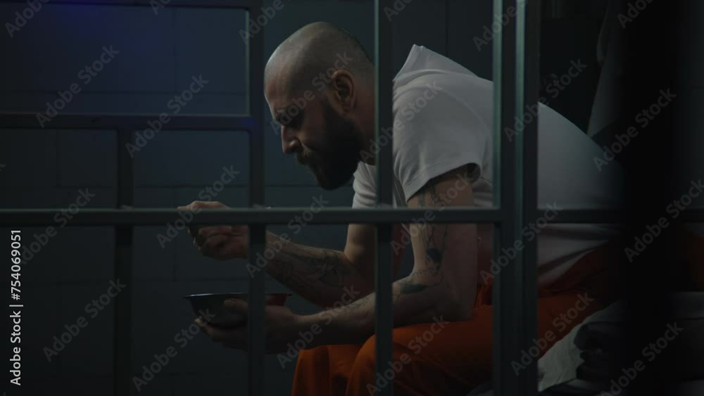 Male prisoner in orange uniform tries to eat disgusting prison food ...