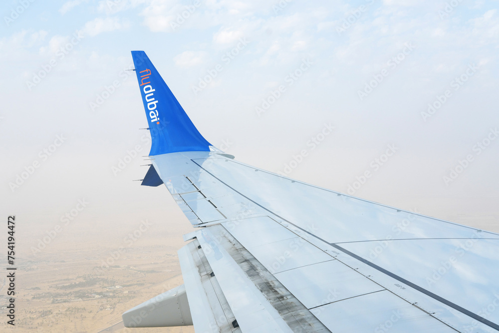 Airplane Wing Over Desert Landscape During Flight. View of a blue ...