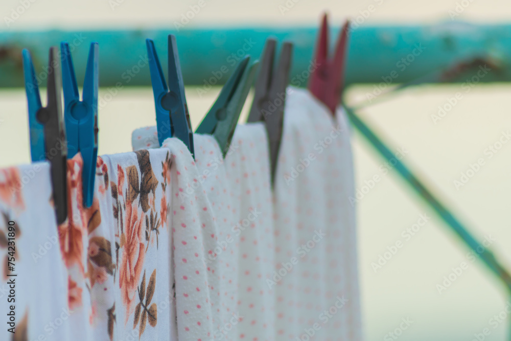 Colorful clothes after washing are hung on a clothesline to dry in the ...
