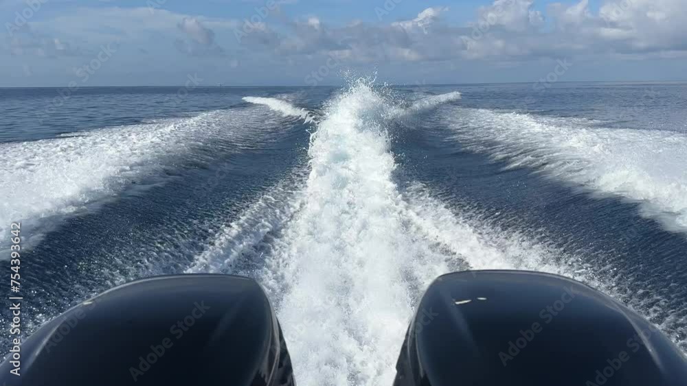Waves from the engines of a high-speed boat. Rear view. Blue sky, white ...