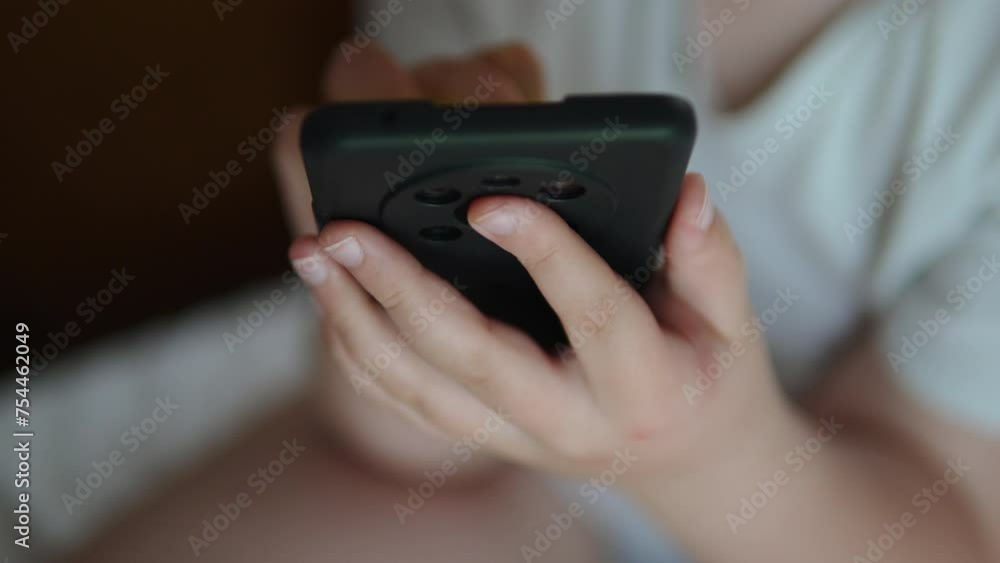 Unrecognizable caucasian boy of 10 years old is holding black phone in ...
